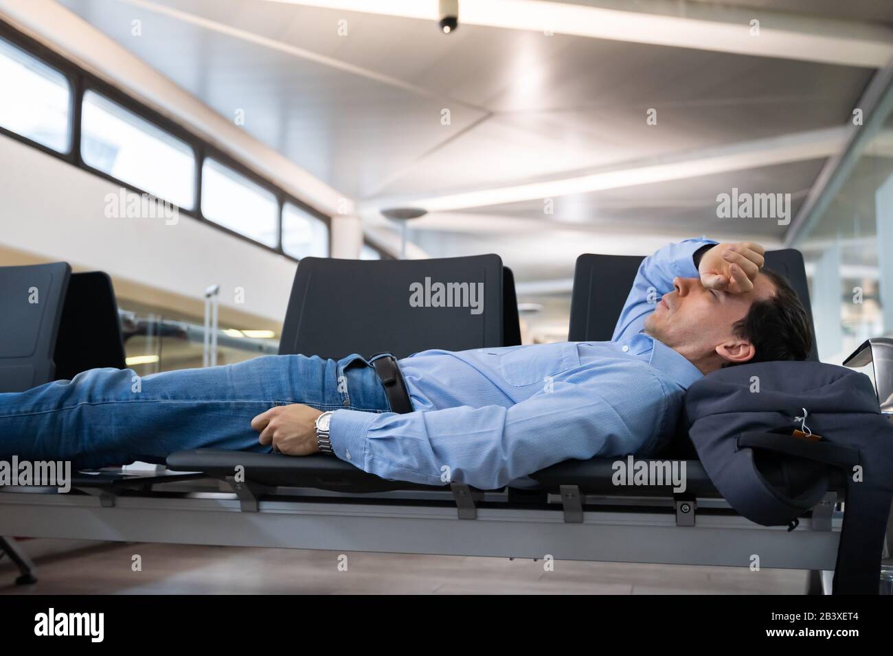 Delayed Flight. Man Sleeping In Airport Terminal Stock Photo - Alamy