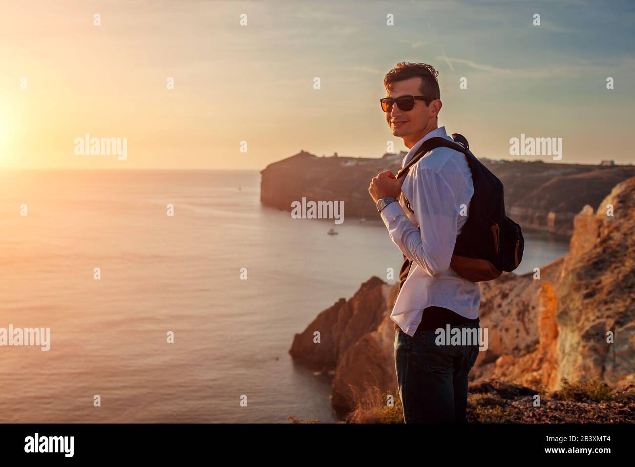 Tourist hiker walking by White beach on Aegean sea Santorini island ...