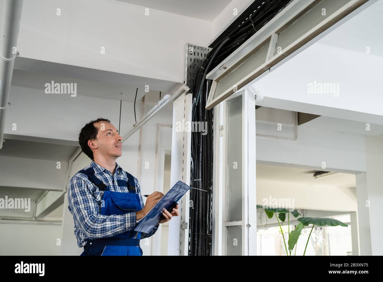 Portrait Of Male Male Electrician Installing Cables Stock Photo - Alamy