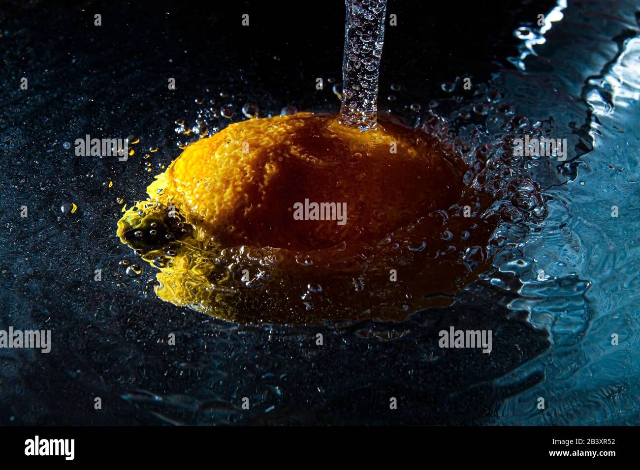 One fresh lemon under running water. Lemon with drops of water Stock ...
