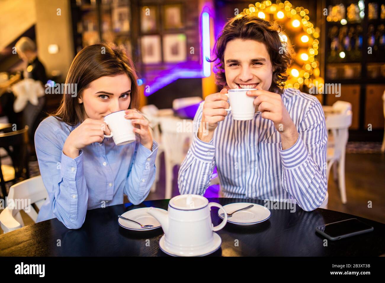 Cute couple having coffee together in cafe Stock Photo - Alamy