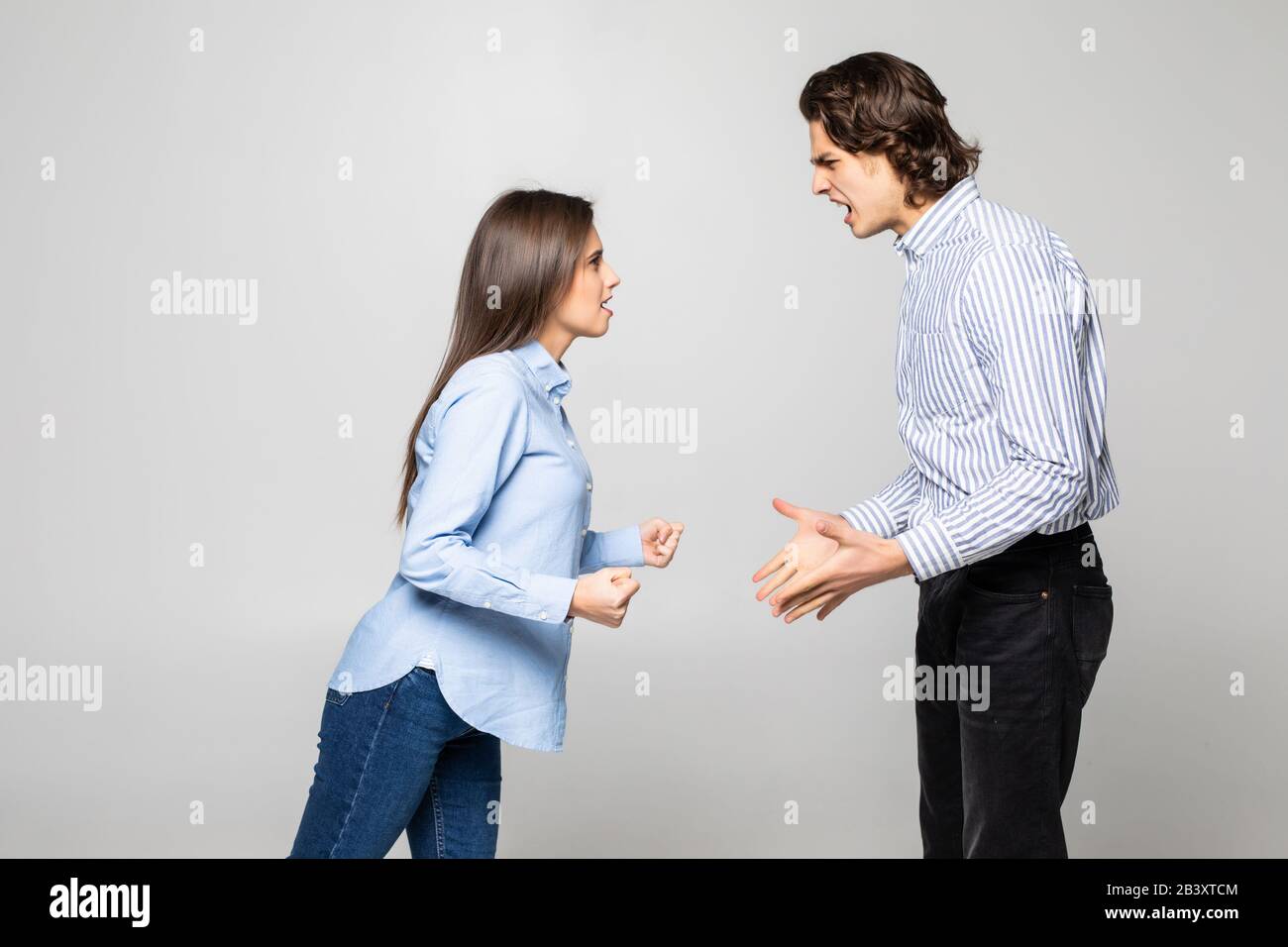 Angry couple shouting at each other on white background Stock Photo - Alamy