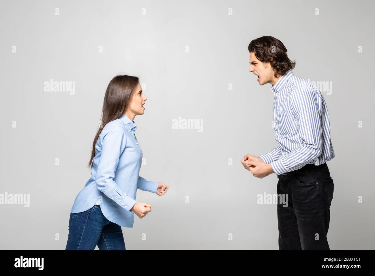 Angry couple shouting at each other on white background Stock Photo - Alamy