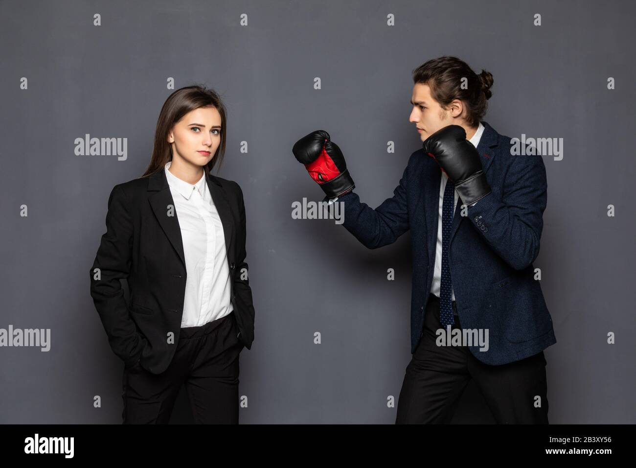 A businessman receiving punch to the side of his head from his co ...