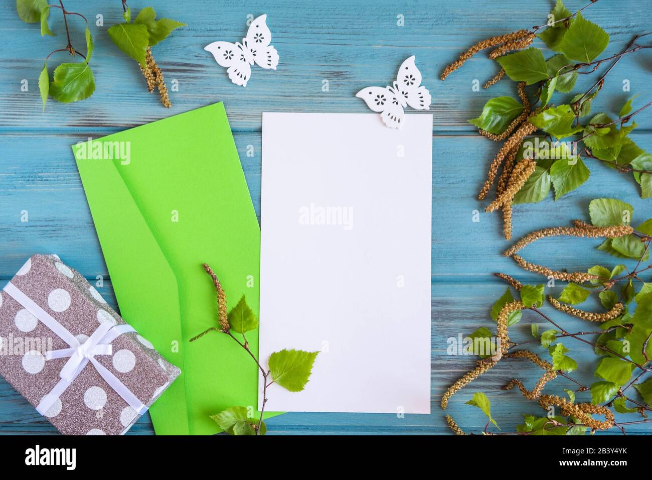 Mock up blank of a spring blank with birch branches on an aged blue ...