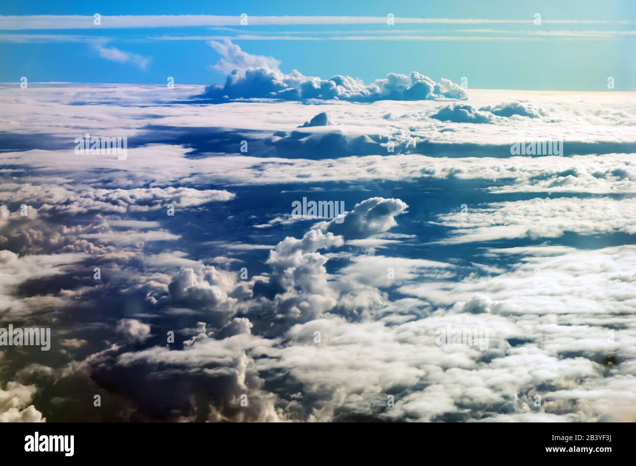 View from the airplane porthole to dramatic clouds above the ground ...