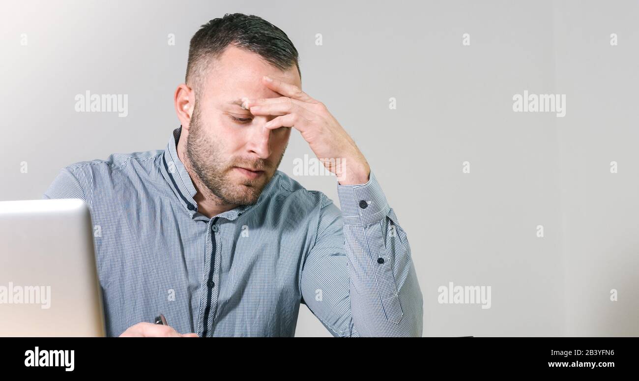 Frustrated businessman under stress nervously filling 1040 tax form ...