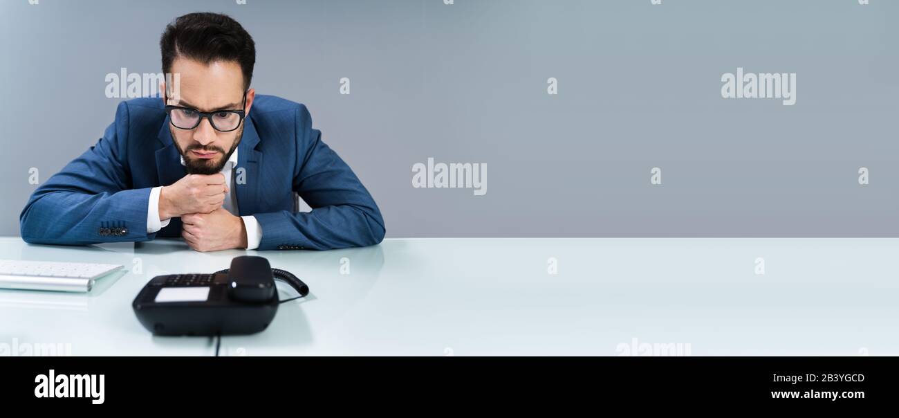Sad Businessman Waiting For A Call On Landline Stock Photo - Alamy