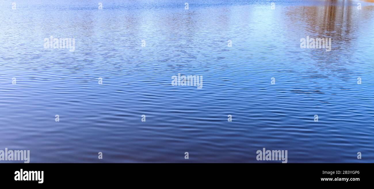 Beautiful smooth water surface texture with small waves and sunlight ...