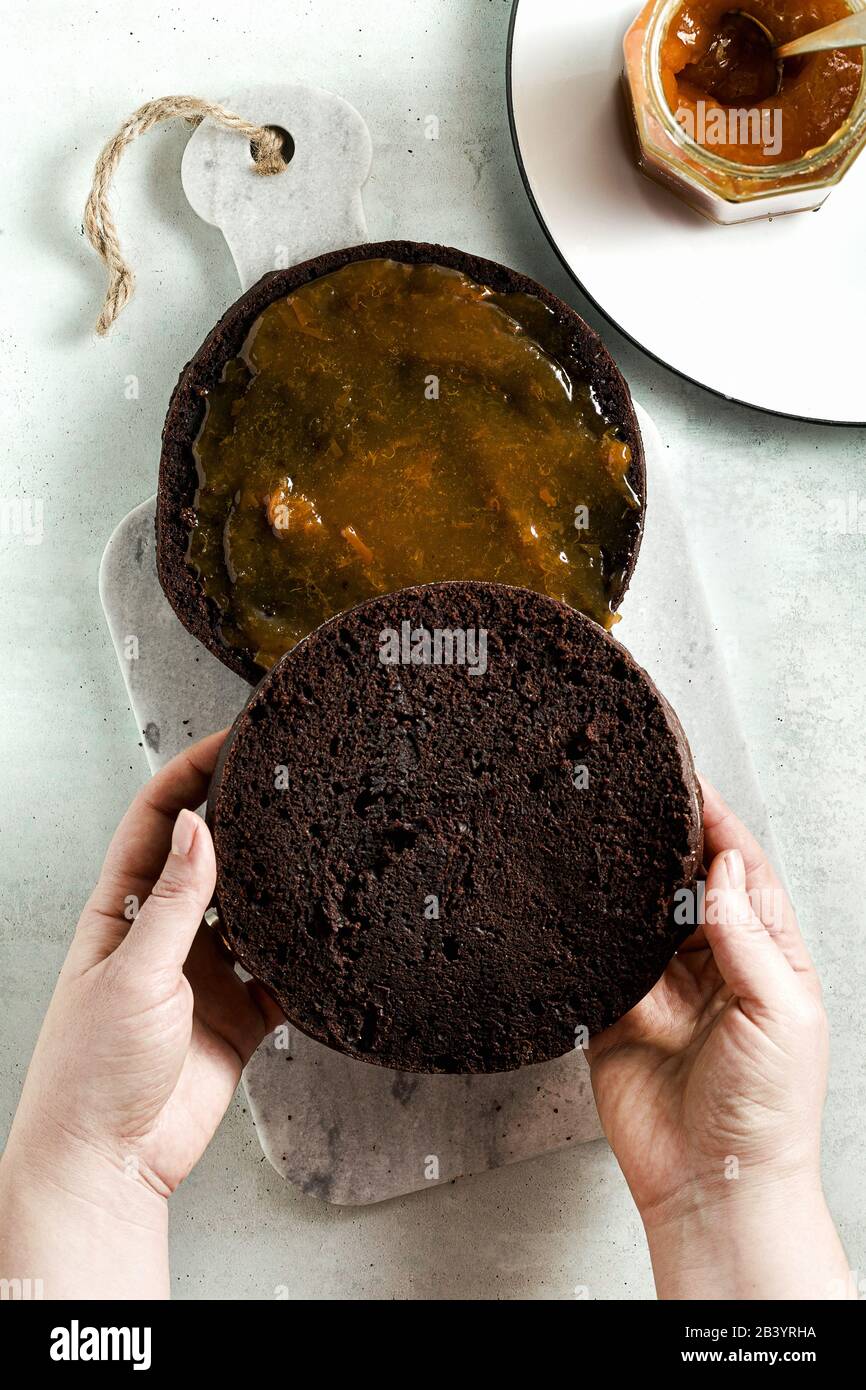 smearing chocolate cake with jam, step by step recipe Stock Photo - Alamy