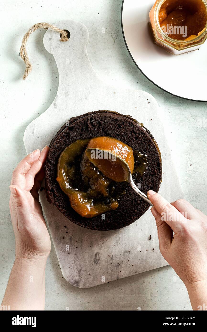 smearing chocolate cake with jam, step by step recipe Stock Photo - Alamy
