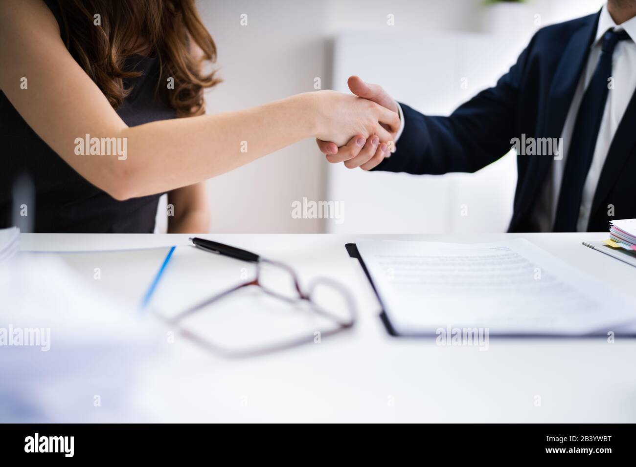 Business Partners Shaking Hands Over Contract Form Stock Photo - Alamy