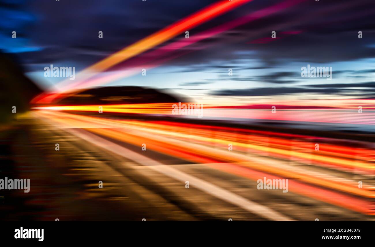 Long exposure capturing red and orange light trails from a speeding ...