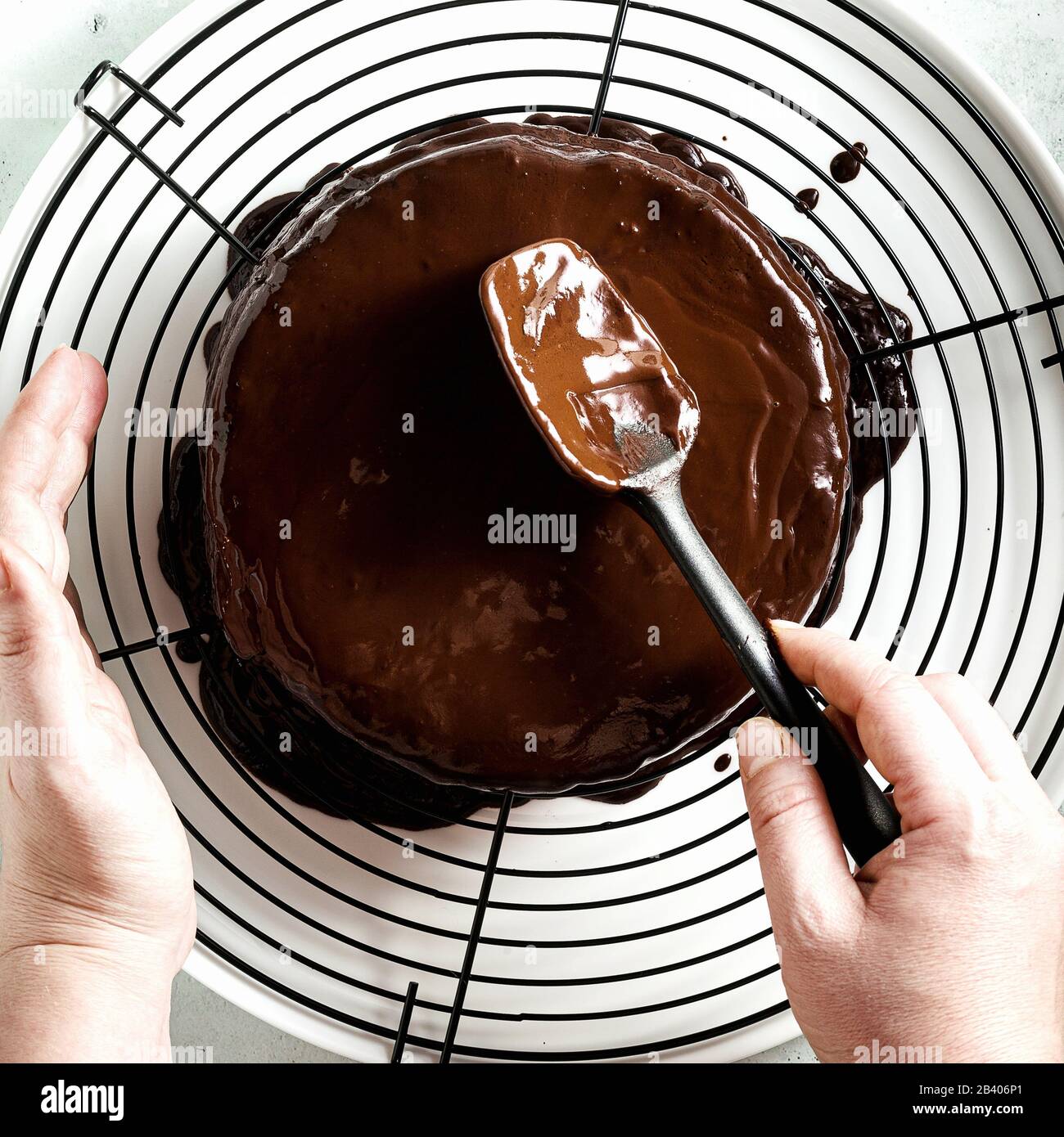 pouring chocolate ganache on the cake. female hands Stock Photo - Alamy