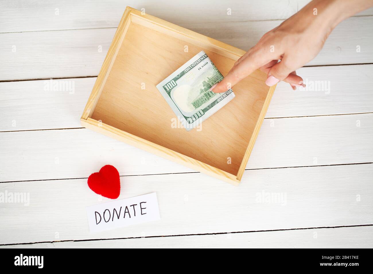 Charity fundraiser box with dollars on white wooden background Stock ...