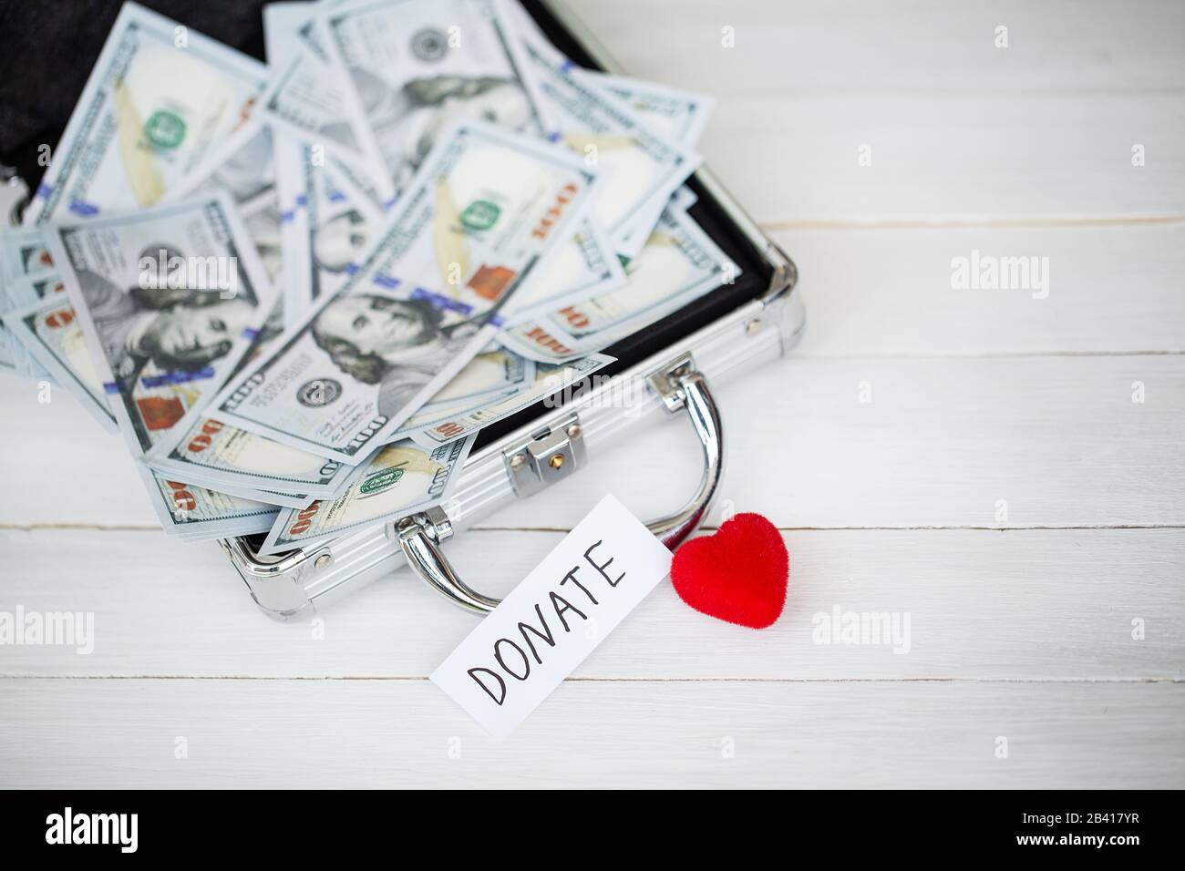 Charity fundraiser box with dollars on white wooden background Stock ...