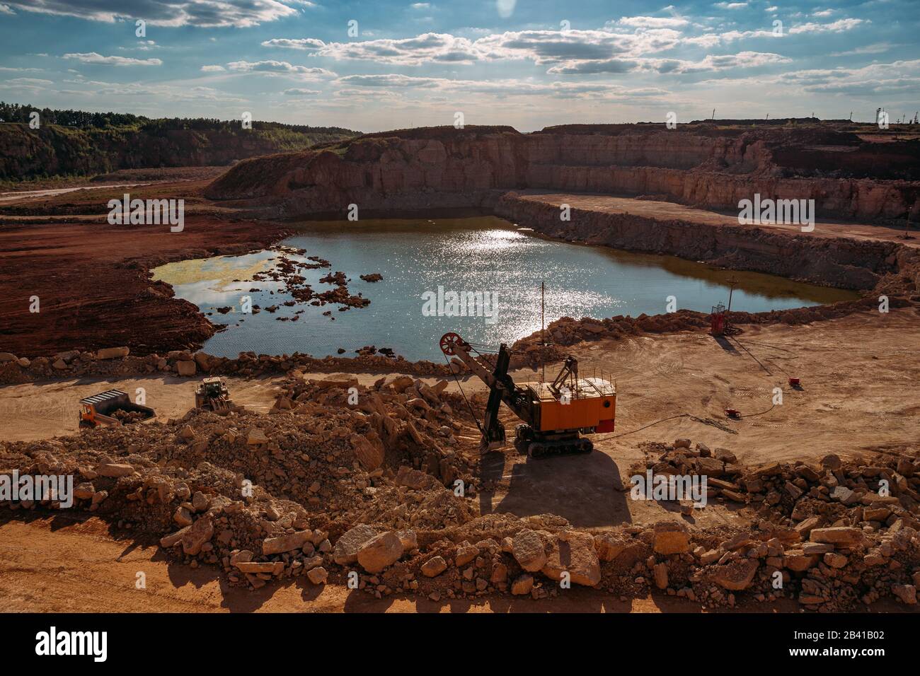 Excavarors working on limestone mining in the flooded quarry Stock ...