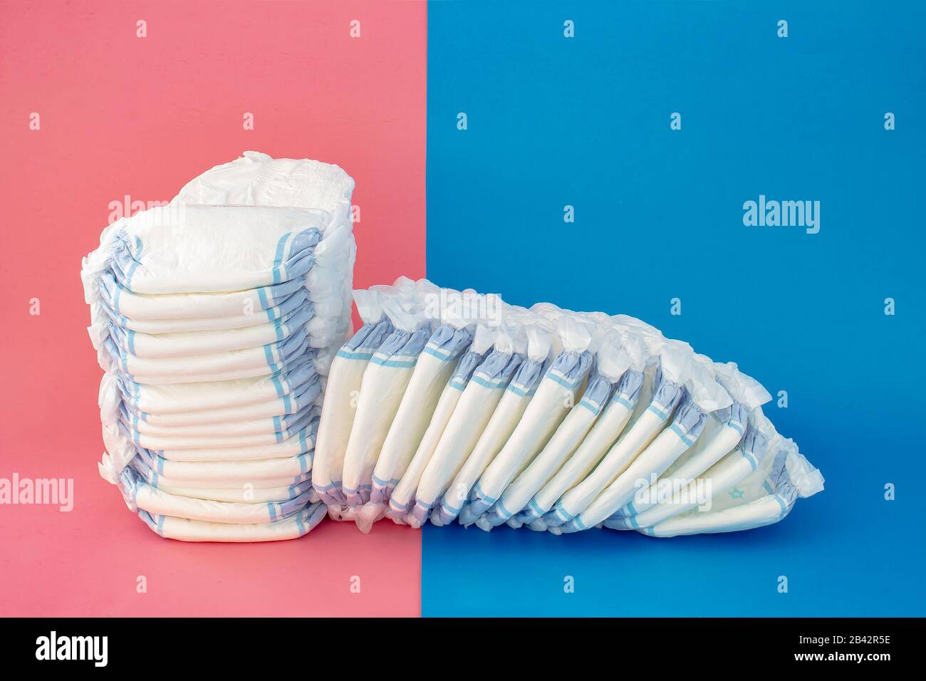 Diapers stack with some diapers falling on the right side on a blue and ...