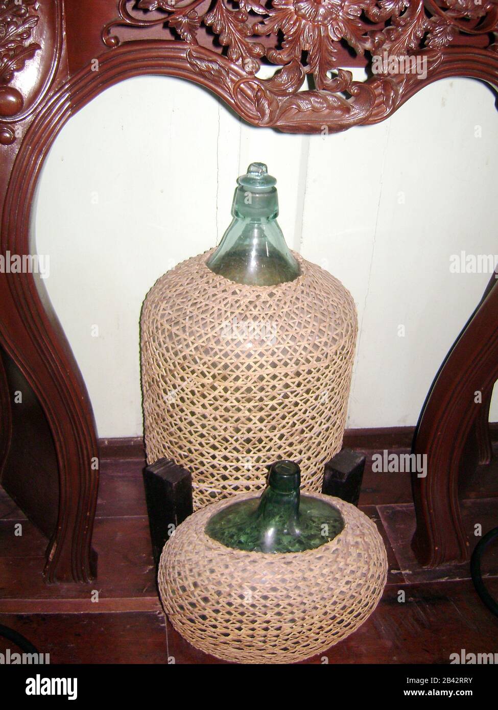 Vintage bottles wrapped in woven rattan displayed in an old house Stock ...
