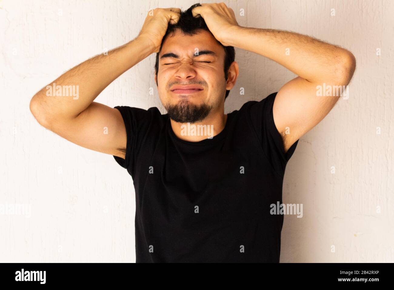 Young short-haired Hispanic man with black clothes, angry, furious ...