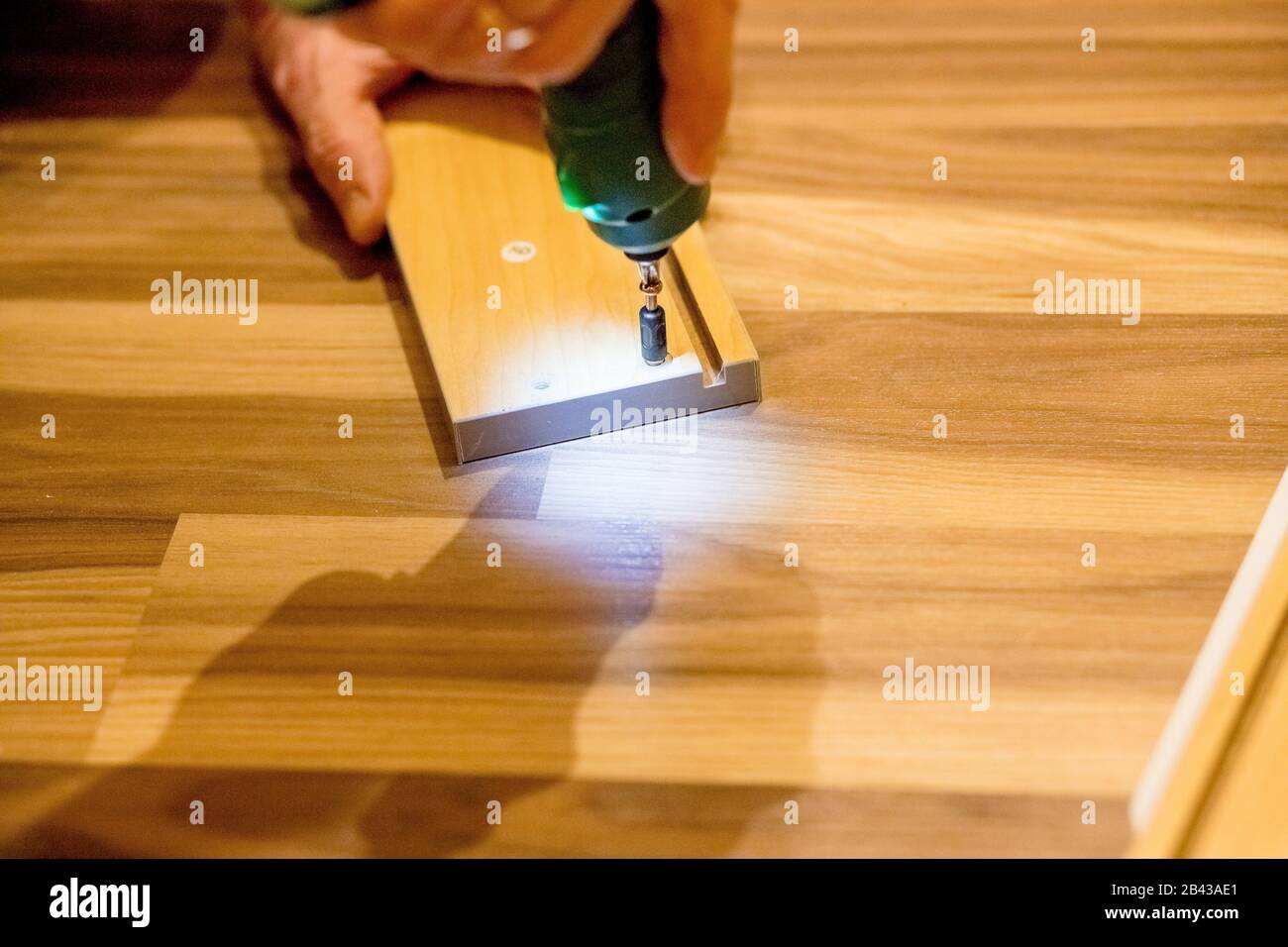 Wooden furniture assembling, woodworker screwing screws using a ...