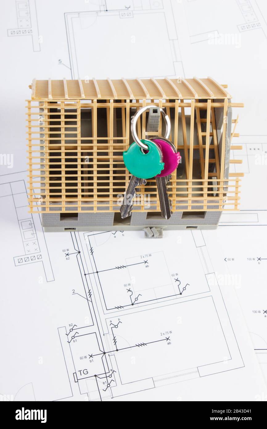 Small house under construction and home keys lying on electrical ...