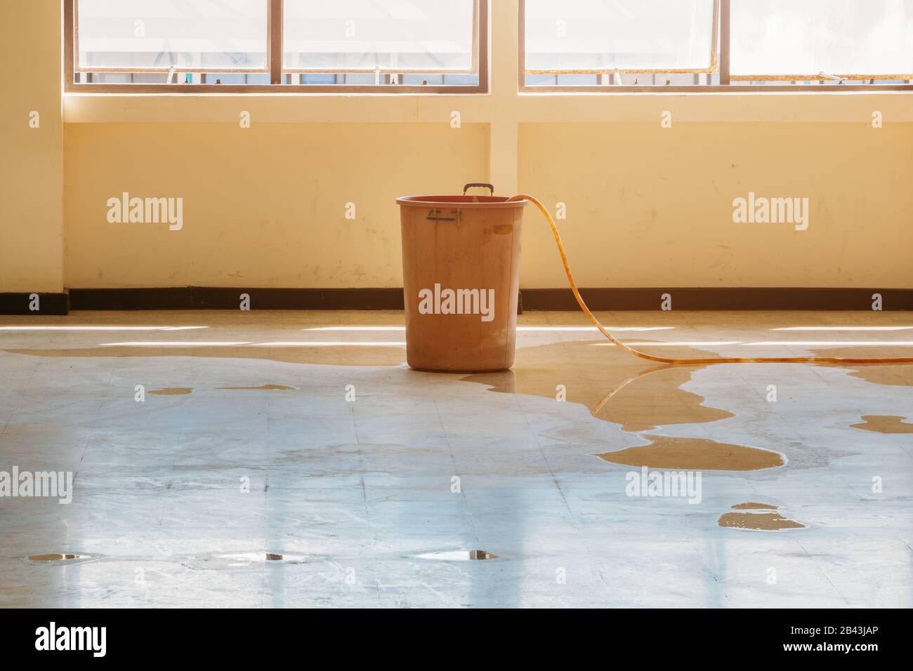 water leak drop interior office building in red bucket from Ceiling and ...