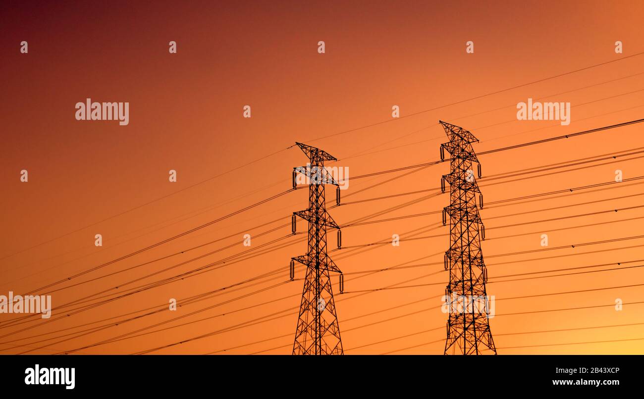 High voltage electric pylon and electrical wire with sunset sky ...