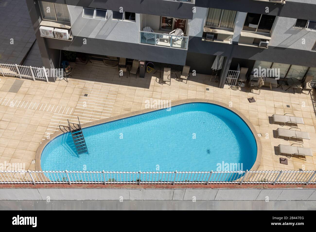 Empty swimming pool enclosed in urban surrounding part of a luxury ...