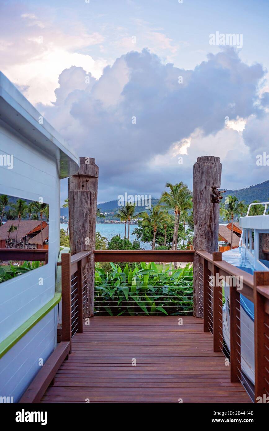 View through gardens out to sea from a narrow deck between two boats ...