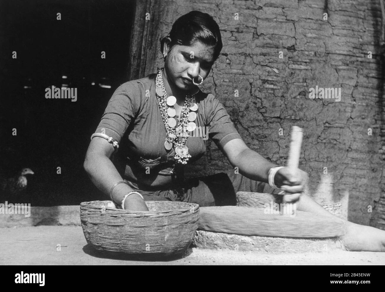 Indian adivasi tribe woman grinding flour wearing silver necklace and ...