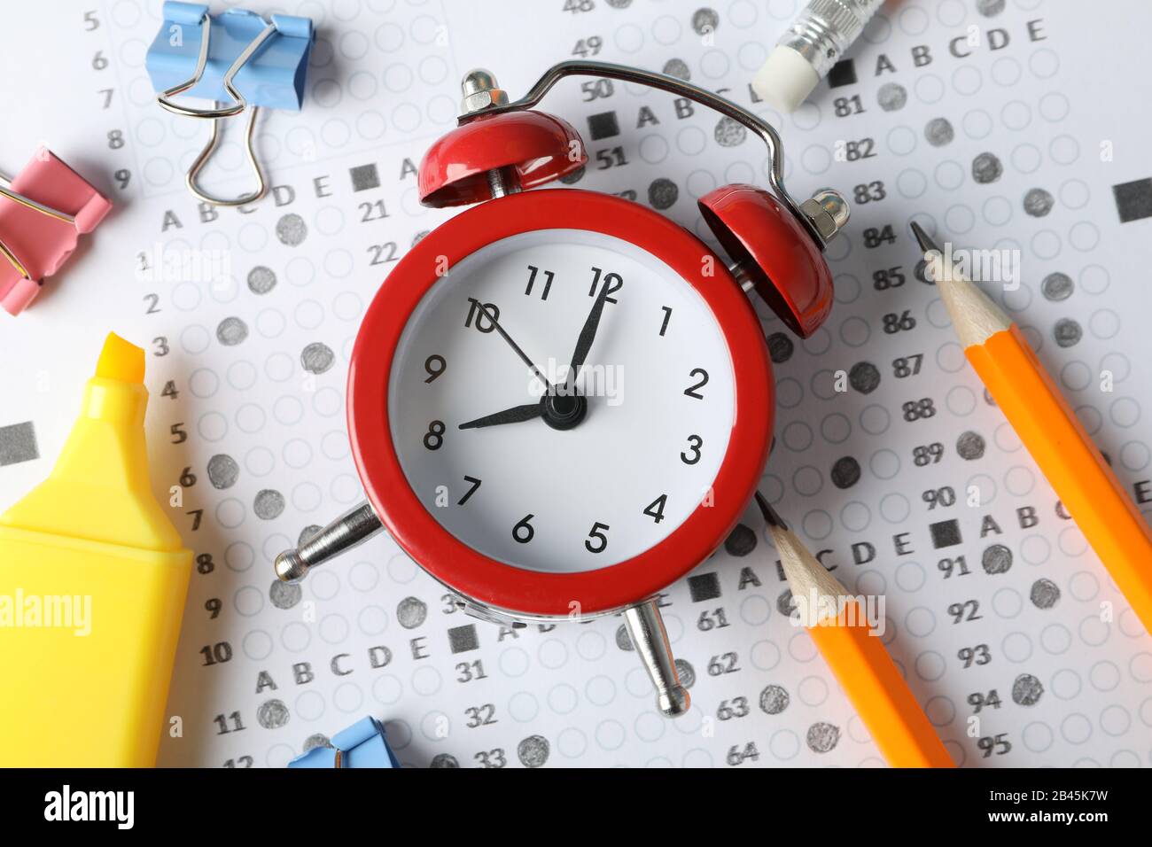 Test score sheet, alarm clock and stationery, close up Stock Photo - Alamy