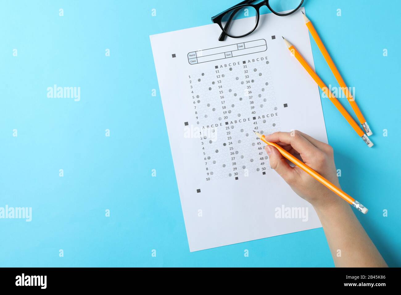 Student fills answers test sheet on blue background, top view Stock ...