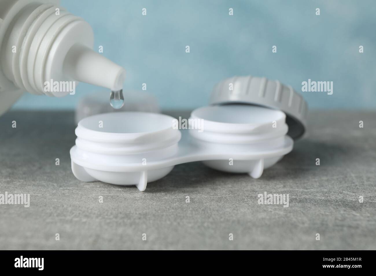 Case for contact lenses and liquid on grey table, close up Stock Photo ...