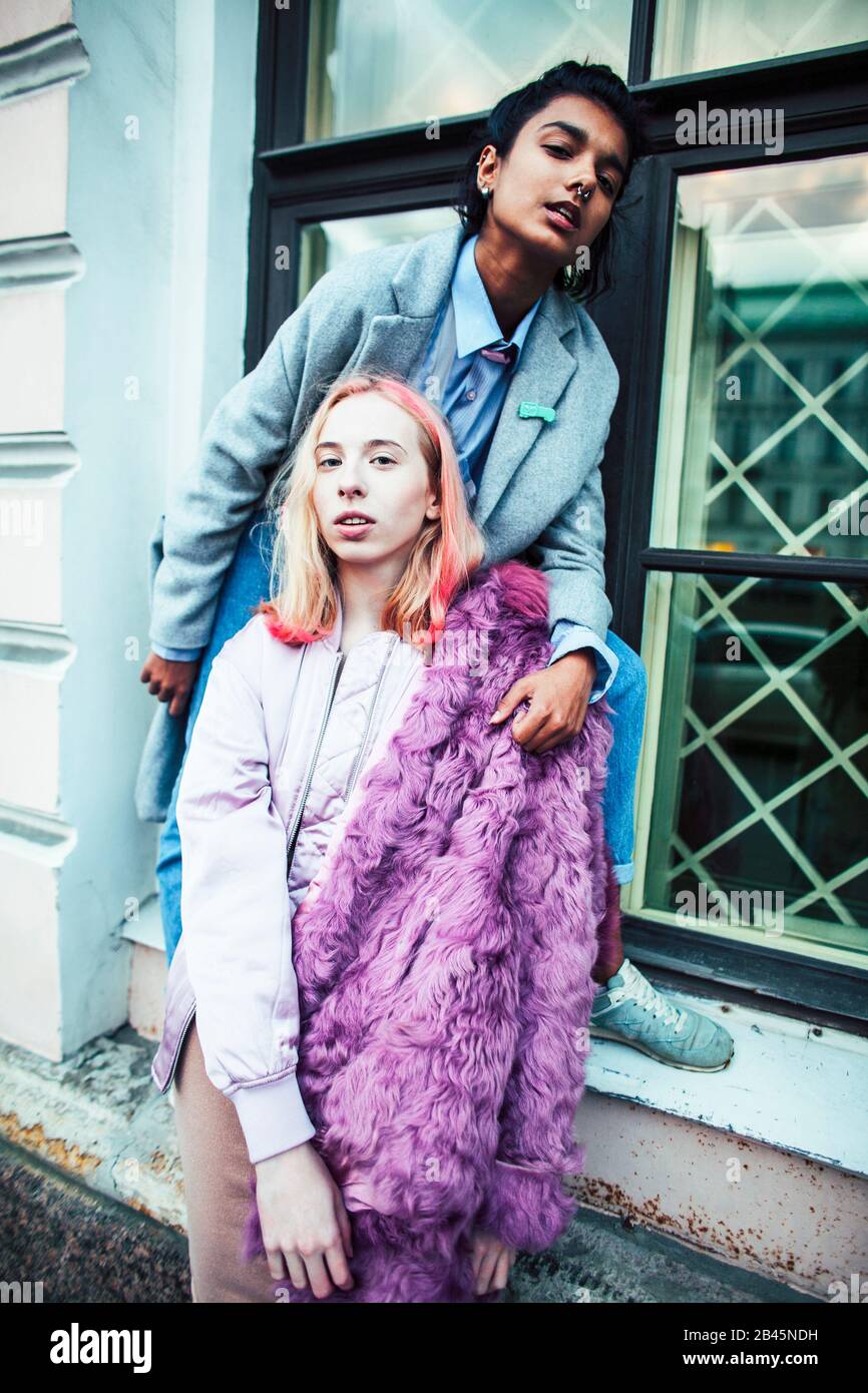 Two teenage girls infront of university building smiling, having fun ...