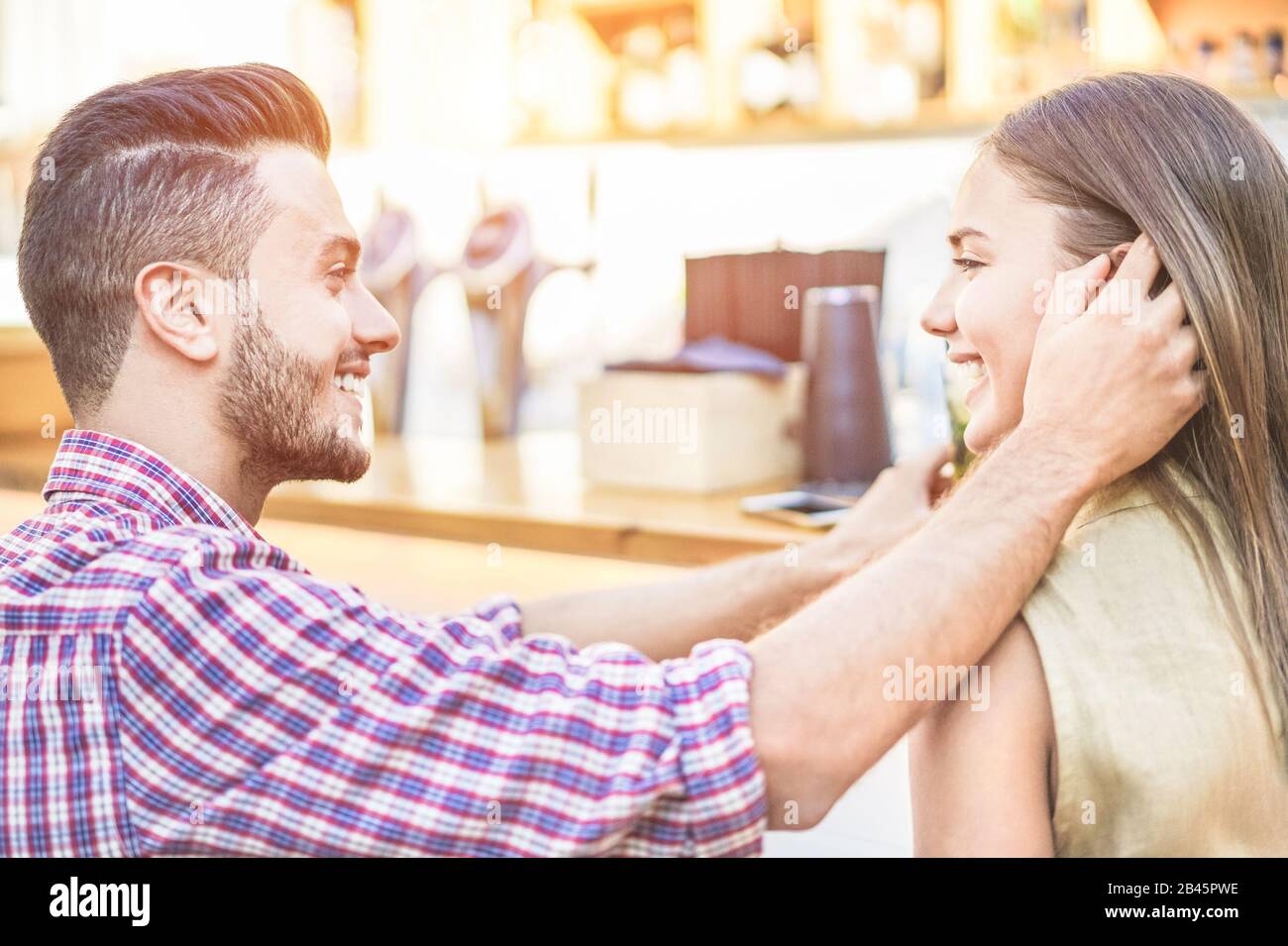 Happy young couple having tender moments and drinking cocktails in ...