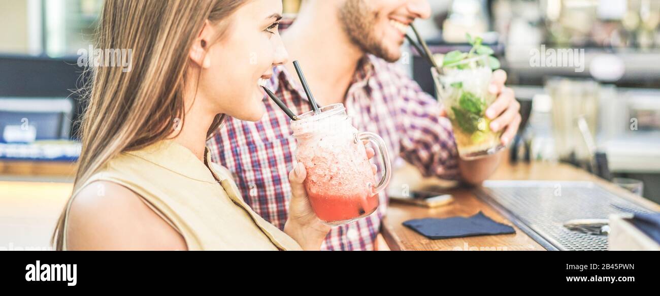Happy trendy couple drinking cocktails in lounge disco bar - Young ...