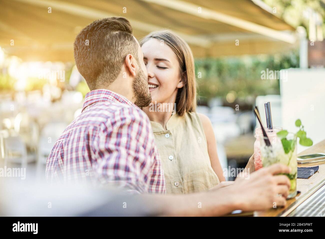 Happy couple toasting cocktails in lounge disco bar for summer vacation ...