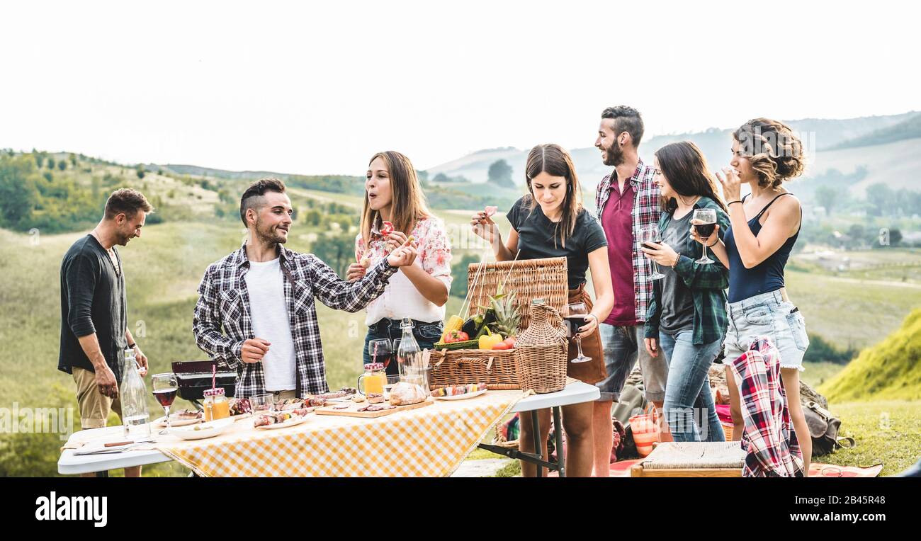Happy adult friends eating at picnic lunch in italian vineyard outdoor ...