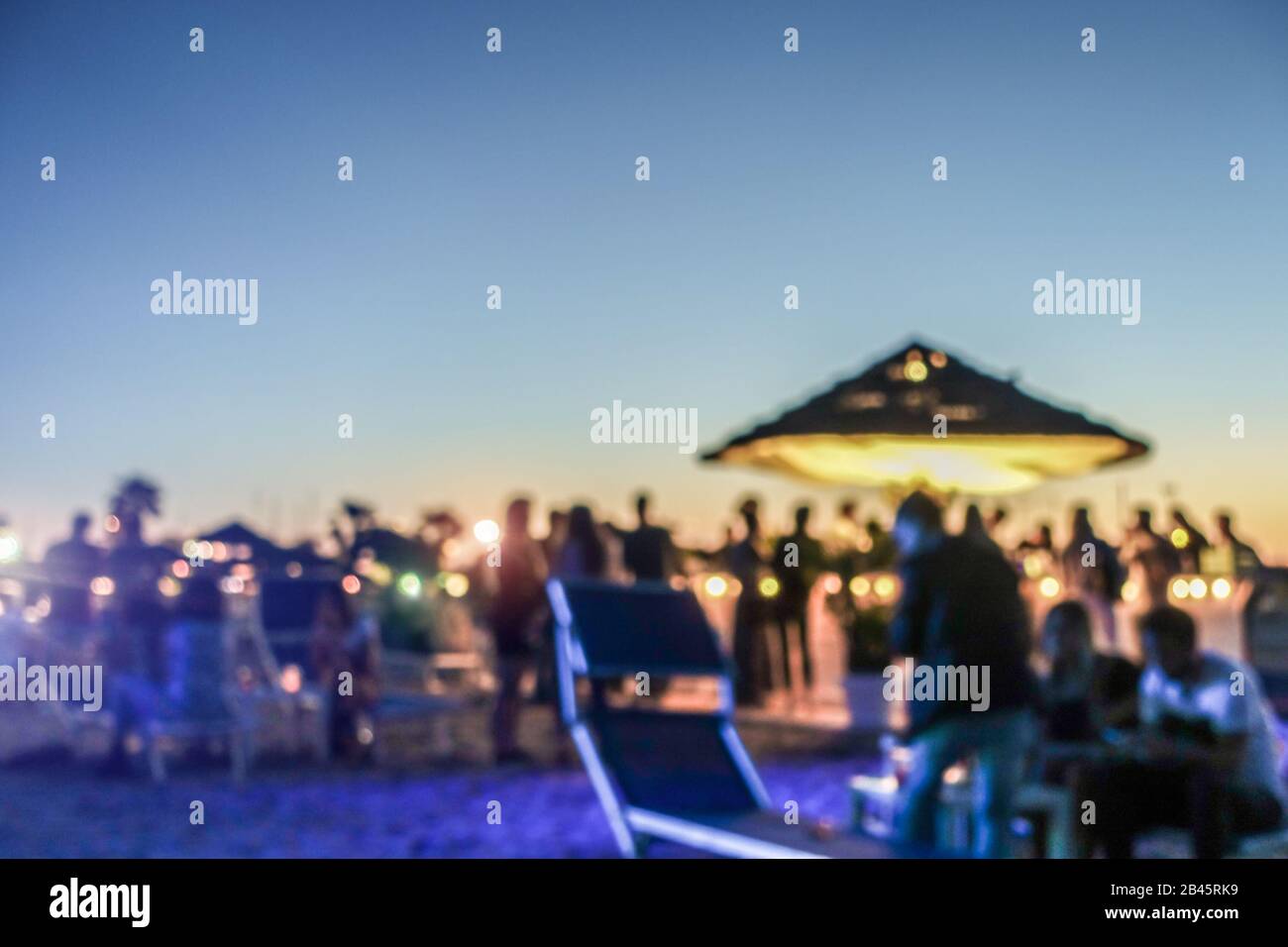 Blurred people having sunset beach party in summer vacation - Defocused ...