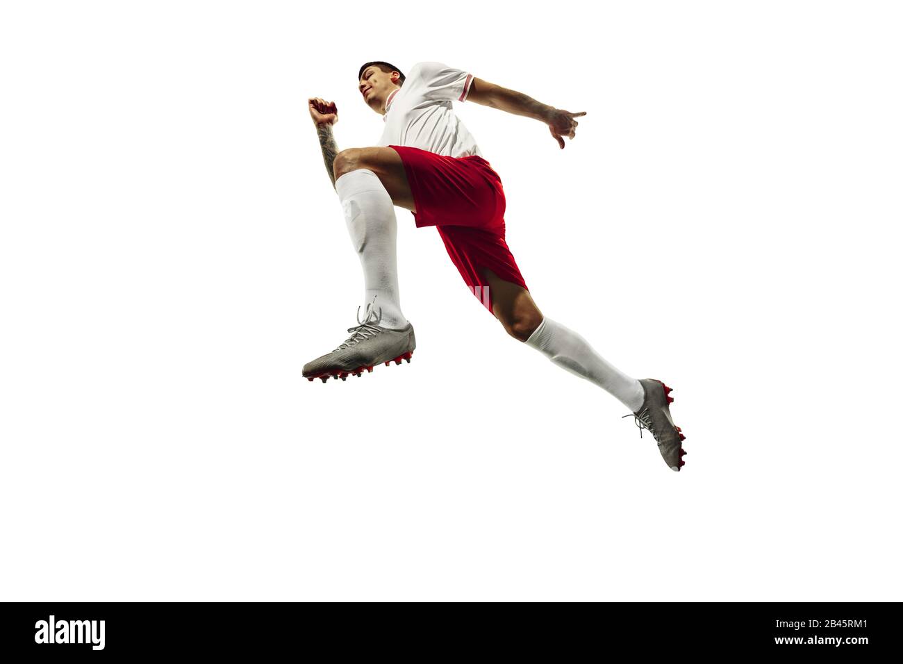 Flight. Football or soccer player on white background with grass. Young ...