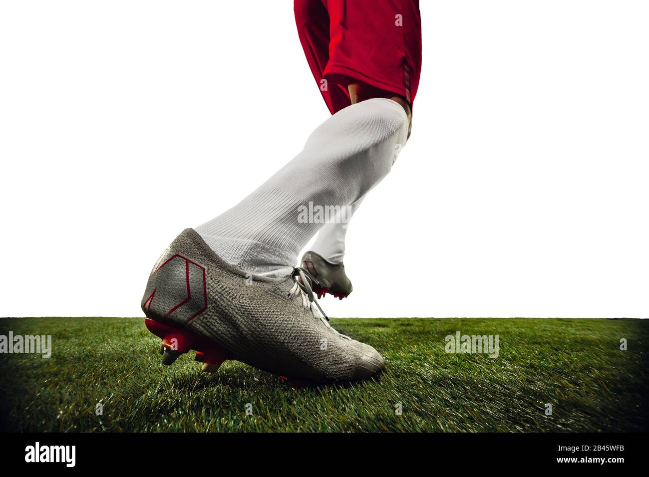 Attack. Football or soccer player on white background with grass. Young ...