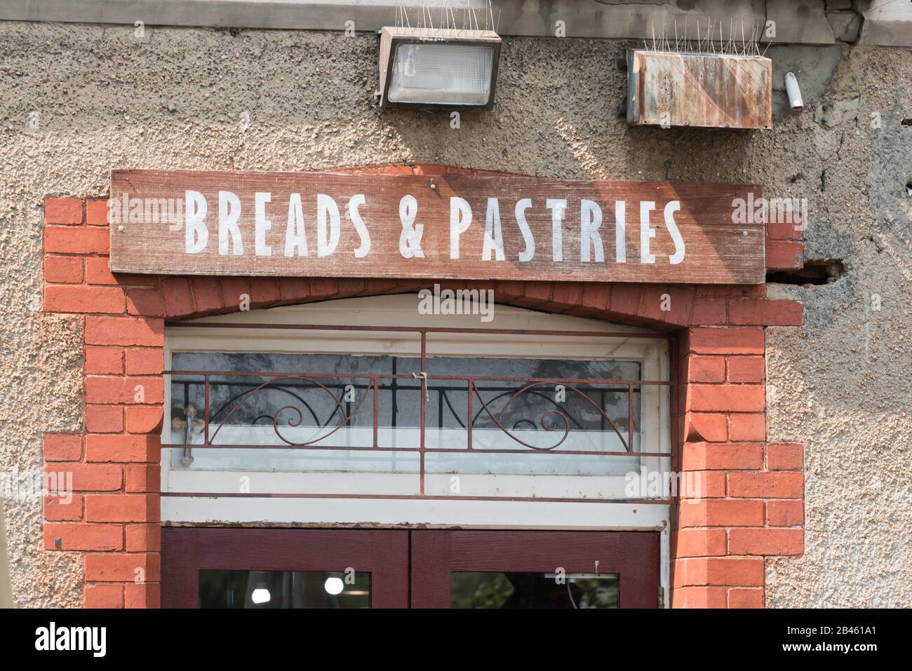 A Bread & Pastries sign painted on a timber board over a doorway at the ...