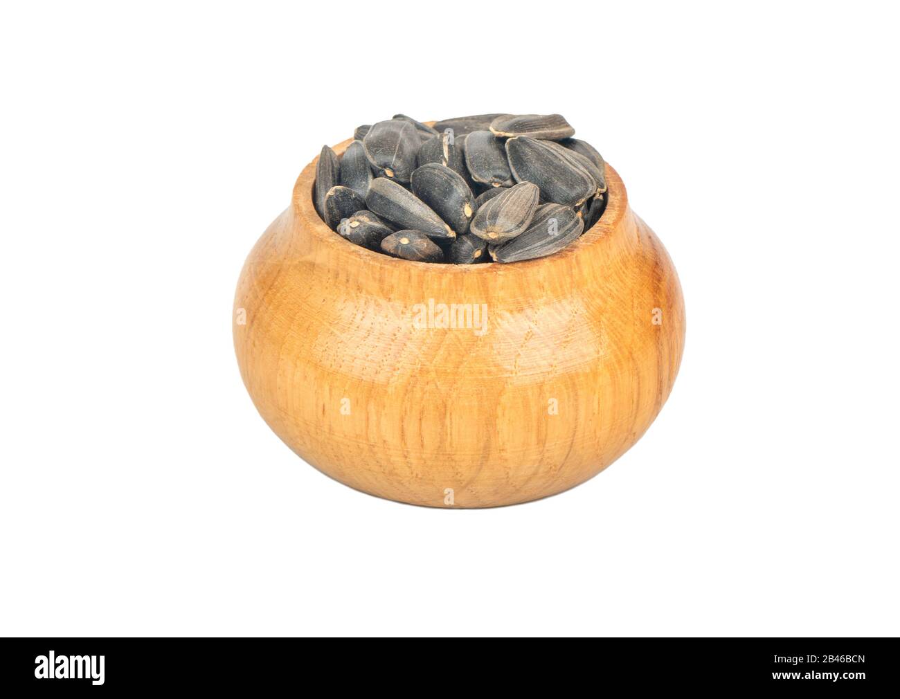 Sunflower seeds in a shell and a wooden container on a white background ...