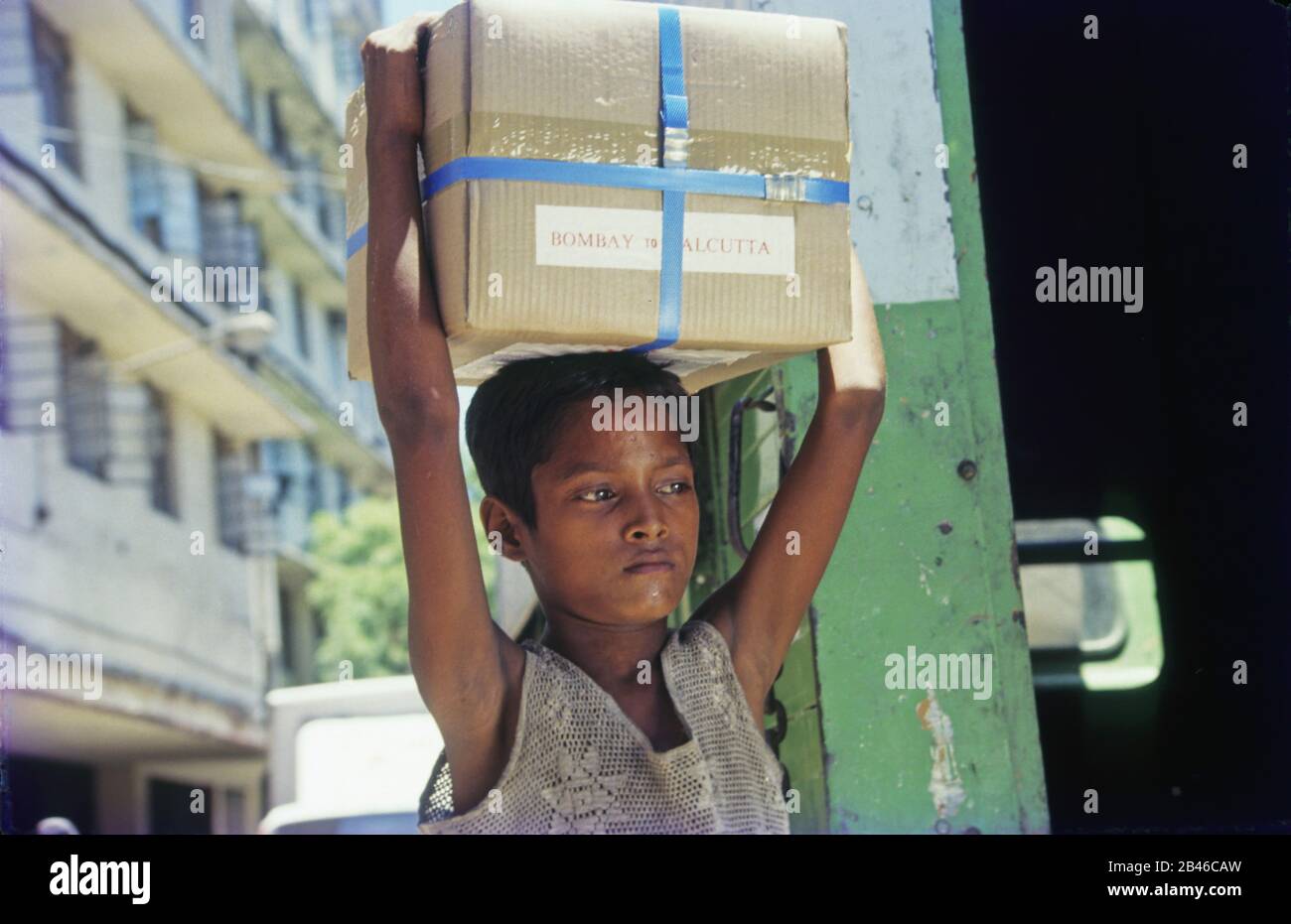boy carrying box on his head, child labour, children working, India ...