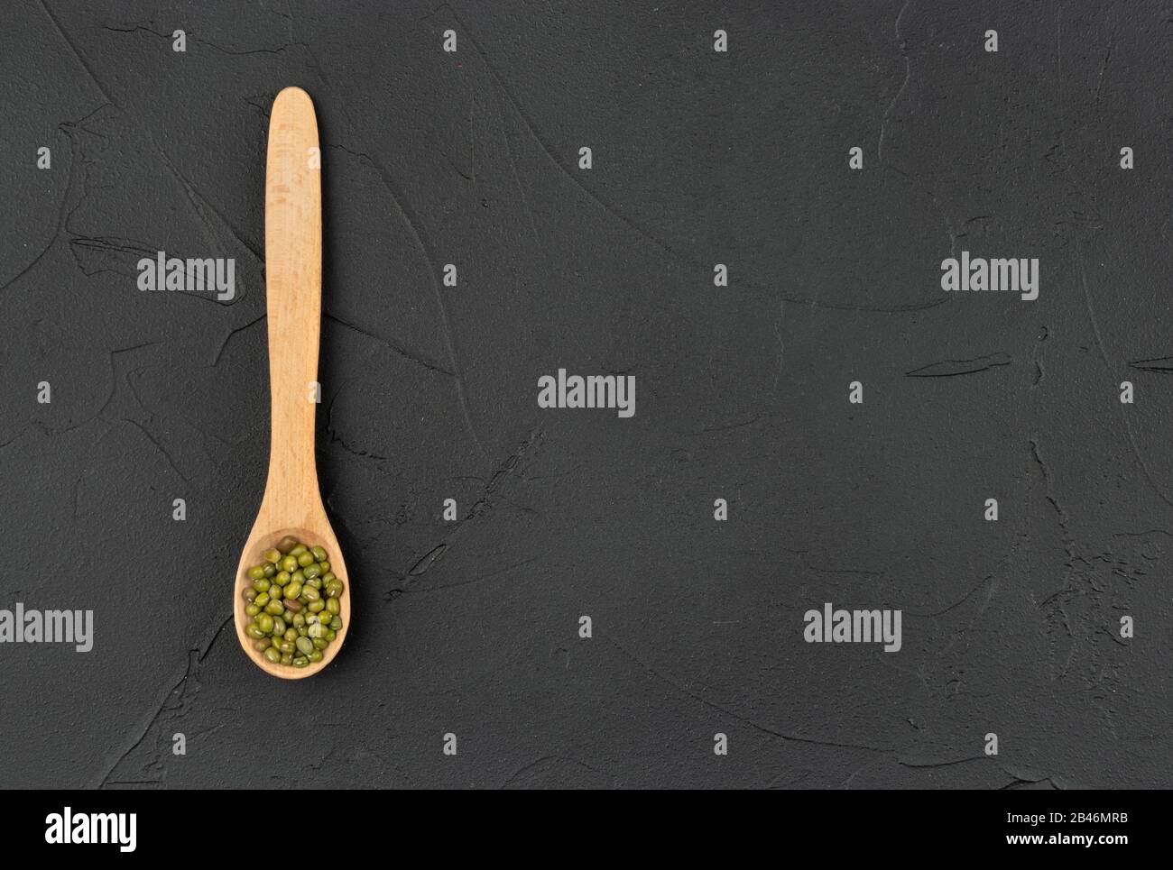 Small spoon with green mung beans on a dark background, top view Stock ...
