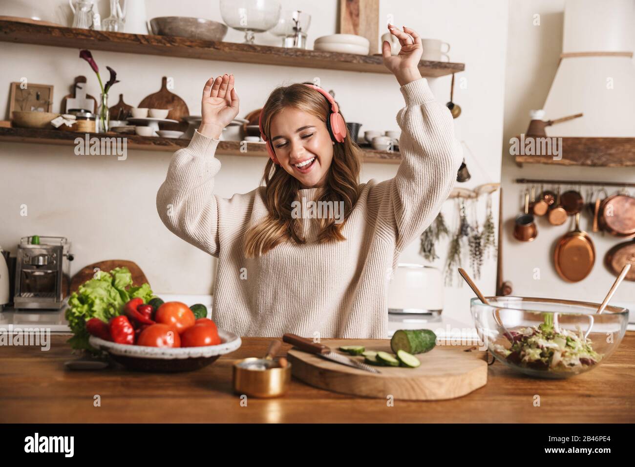 Image of smiling nice woman wearing casual clothes using headphones and ...