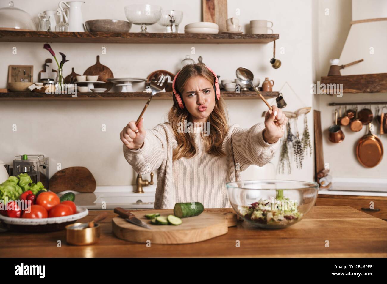 Image of sad nice woman wearing casual clothes using headphones while ...