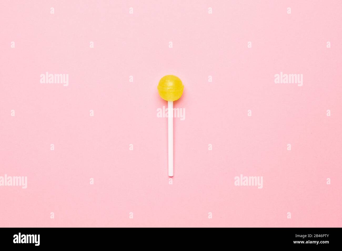 Sweet yellow candy lolipop on pastel pink background.Minimalist ...