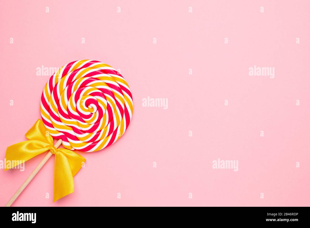 Colorful lolipop with wooden stick, pink, yellow and white spiral on ...
